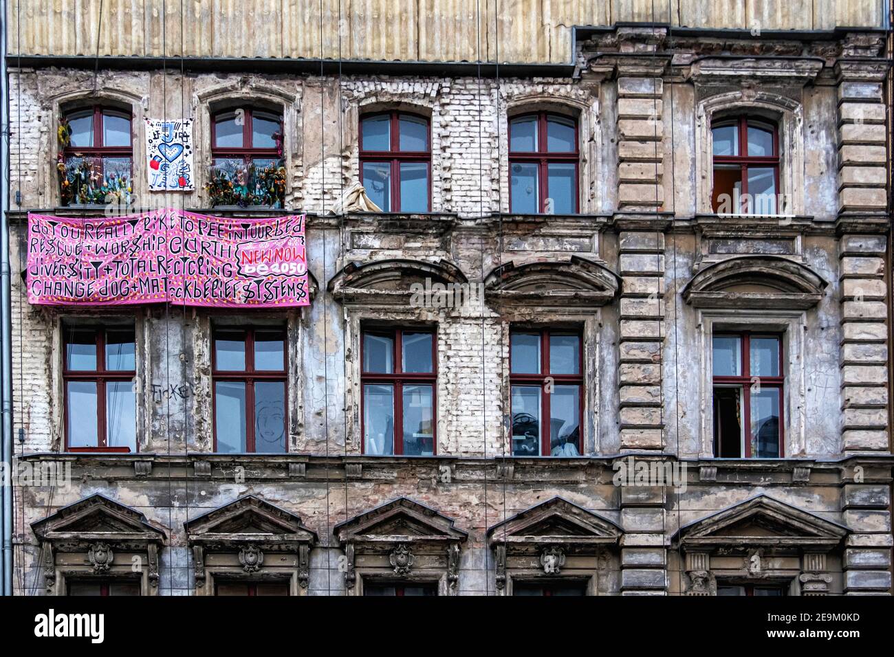Banners on dilapidated, weathered old apartment building in ...