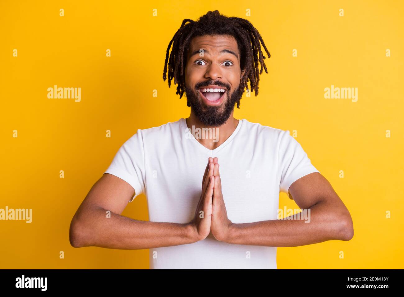 Photo of excited dark skin guy hold arms together begging friend play ...
