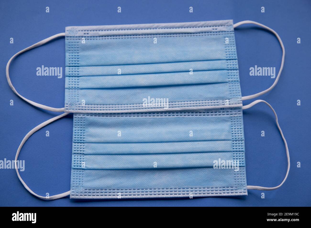 High angle shot of two medical masks placed on a blue background Stock ...