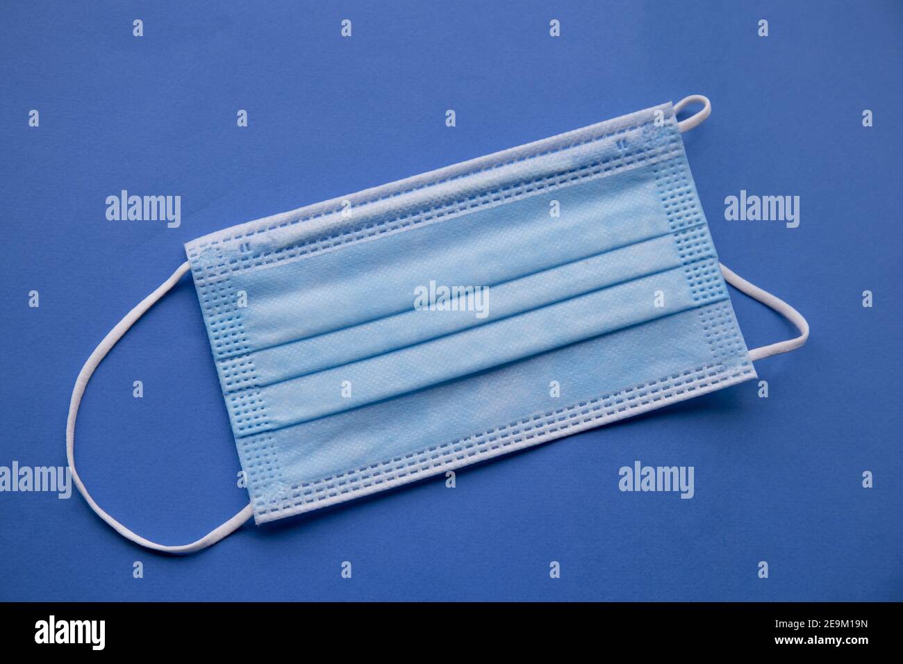 High angle shot of a medical mask placed on a blue background Stock ...