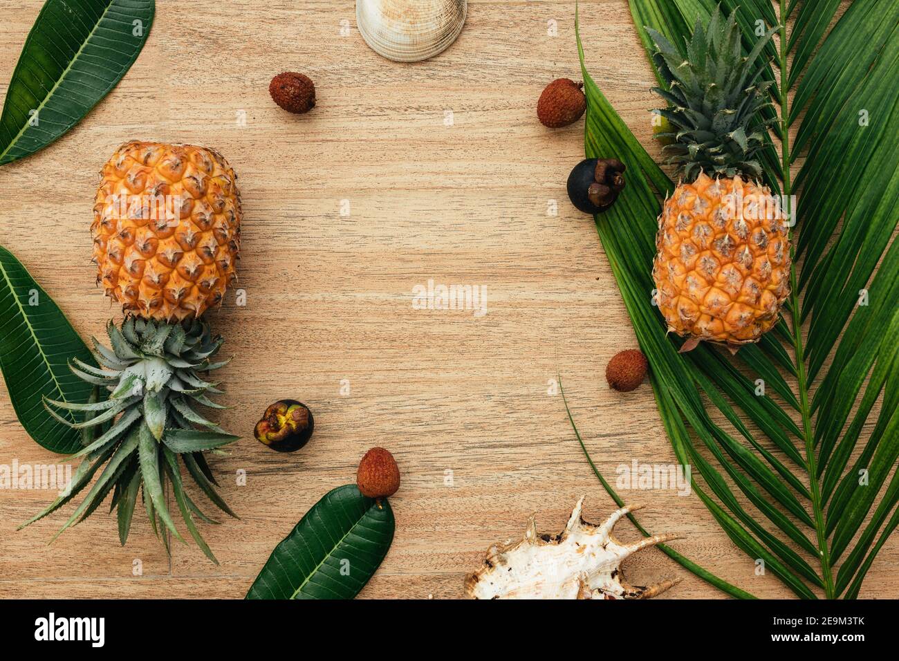 Flat lay. Tropical fruits on a brown background with a beautiful palm ...