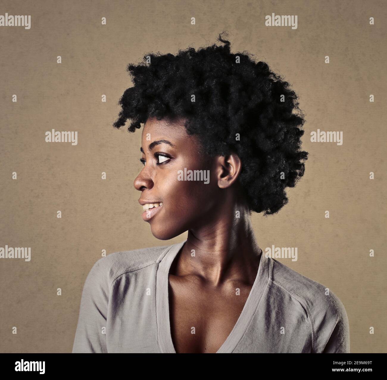 Portrait of the side profile of a young African female with short curly ...
