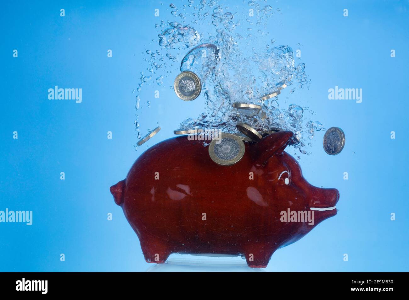 Freeze motion image of Piggy Bank and coins underwater (money ...