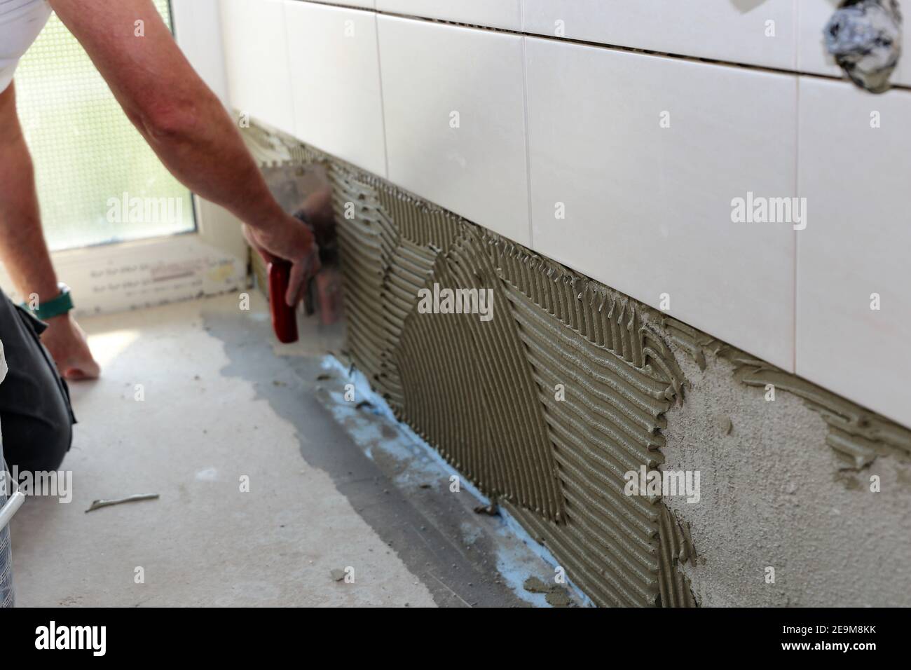 Tiler lays tiles on the wall Stock Photo - Alamy