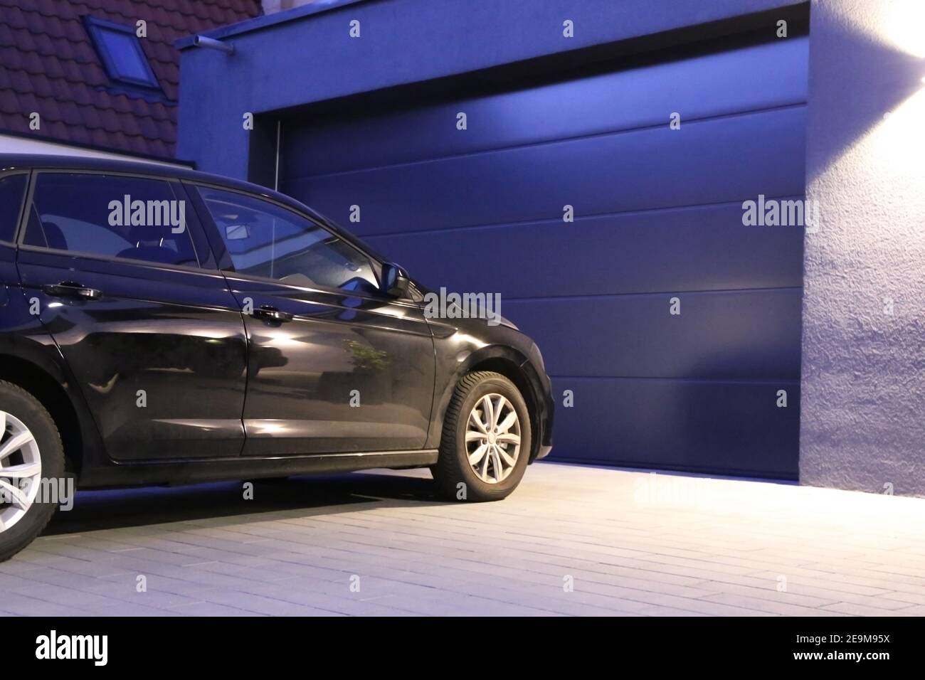 Modern new garage door (sectional door) at night Stock Photo - Alamy