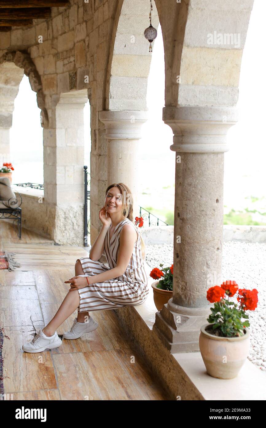 Girl sitting in arch of living room leaning on column Stock Photo - Alamy