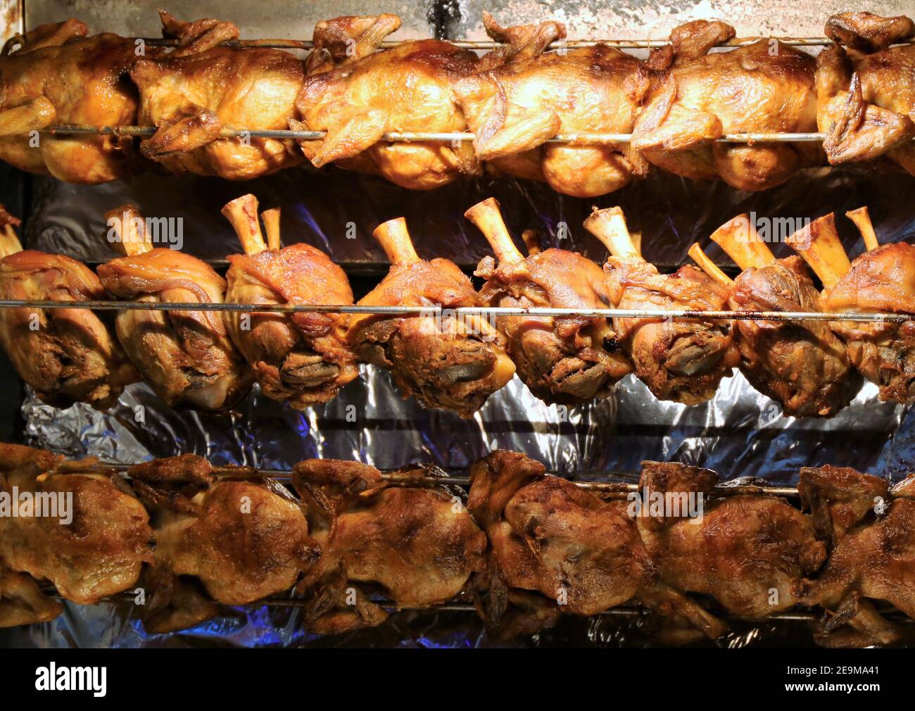 Grilled pork knuckle (roasted pork leg) and roast chicken on the rotary ...