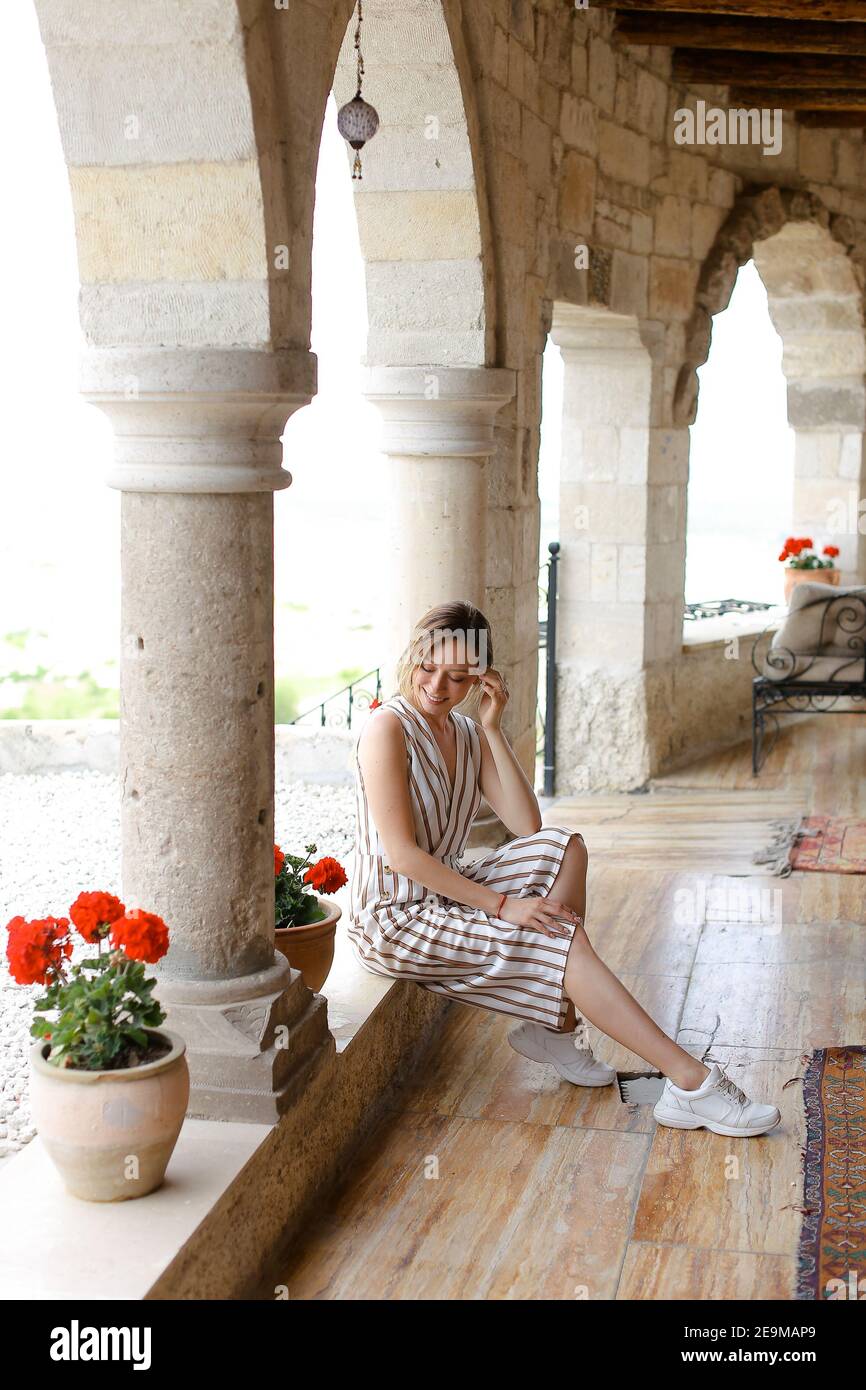 Caucasian girl sitting in arch of living room leaning on column Stock ...
