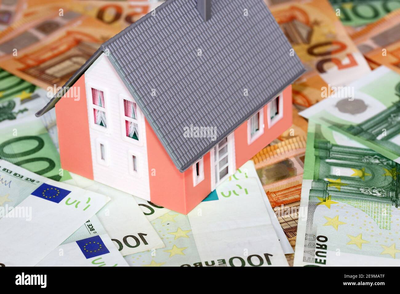 Symbol image: Model house with (euro)banknotes and coins as a symbol ...