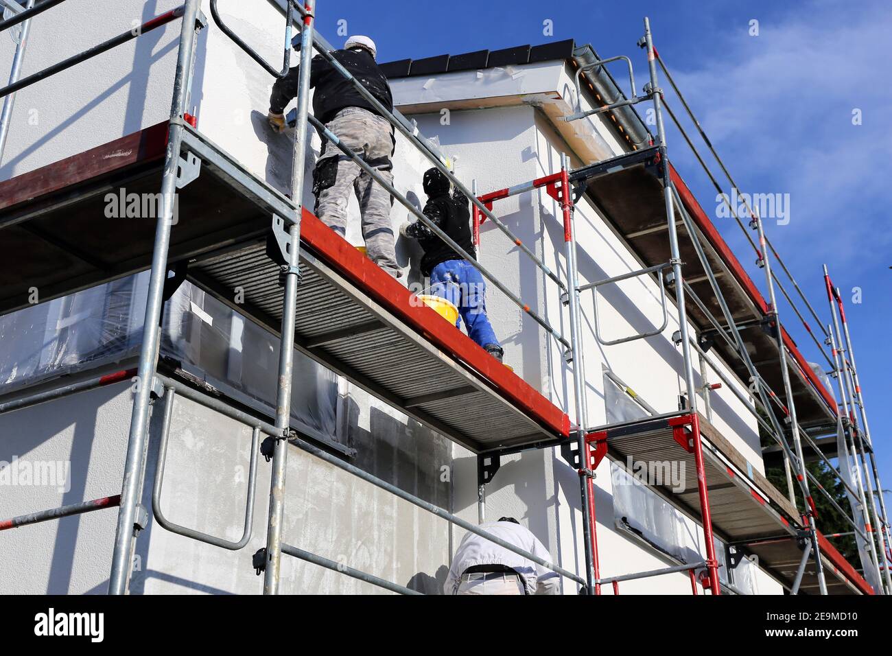 Painter painting the facade of a new residential building Stock Photo ...