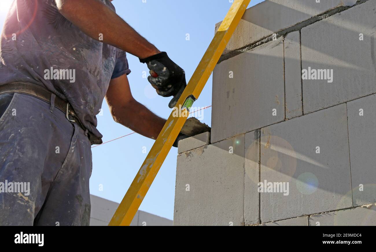 Construction worker (bricklayer) works on the construction site Stock ...