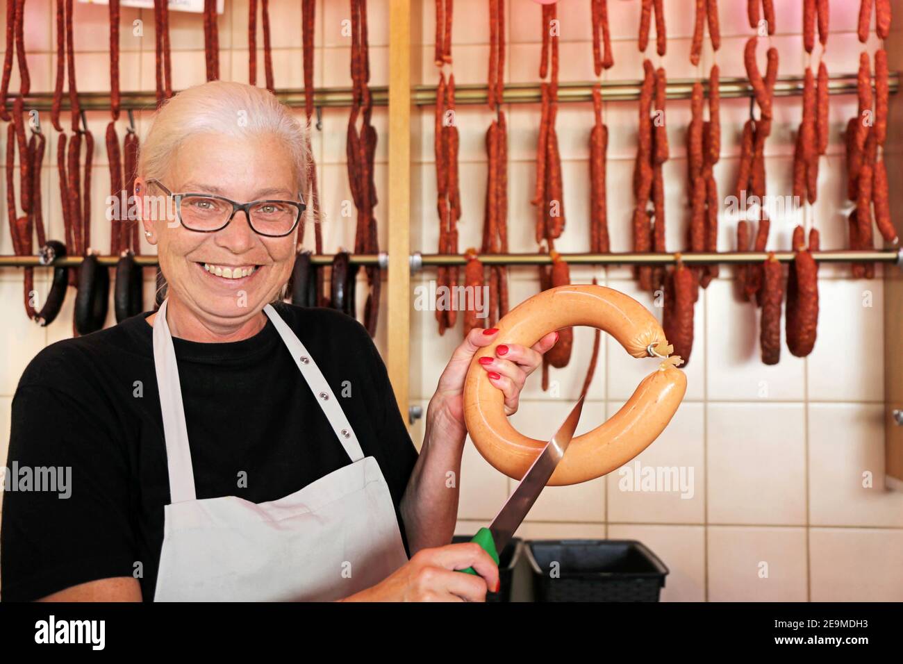 Friendly saleswoman in the butcher shop (model released Stock Photo - Alamy