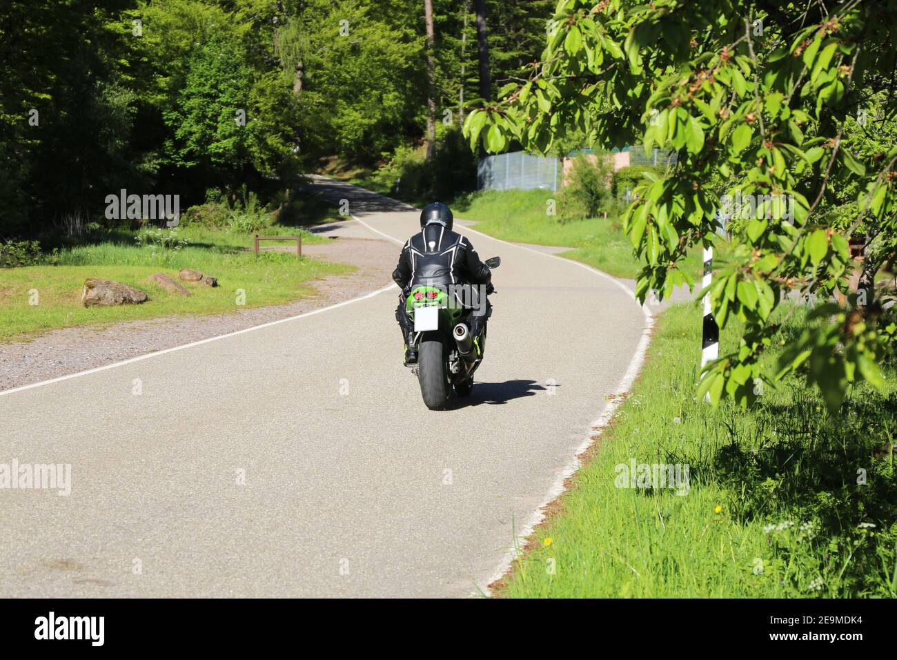 Sporty motorcyclist photographed from behind Stock Photo - Alamy
