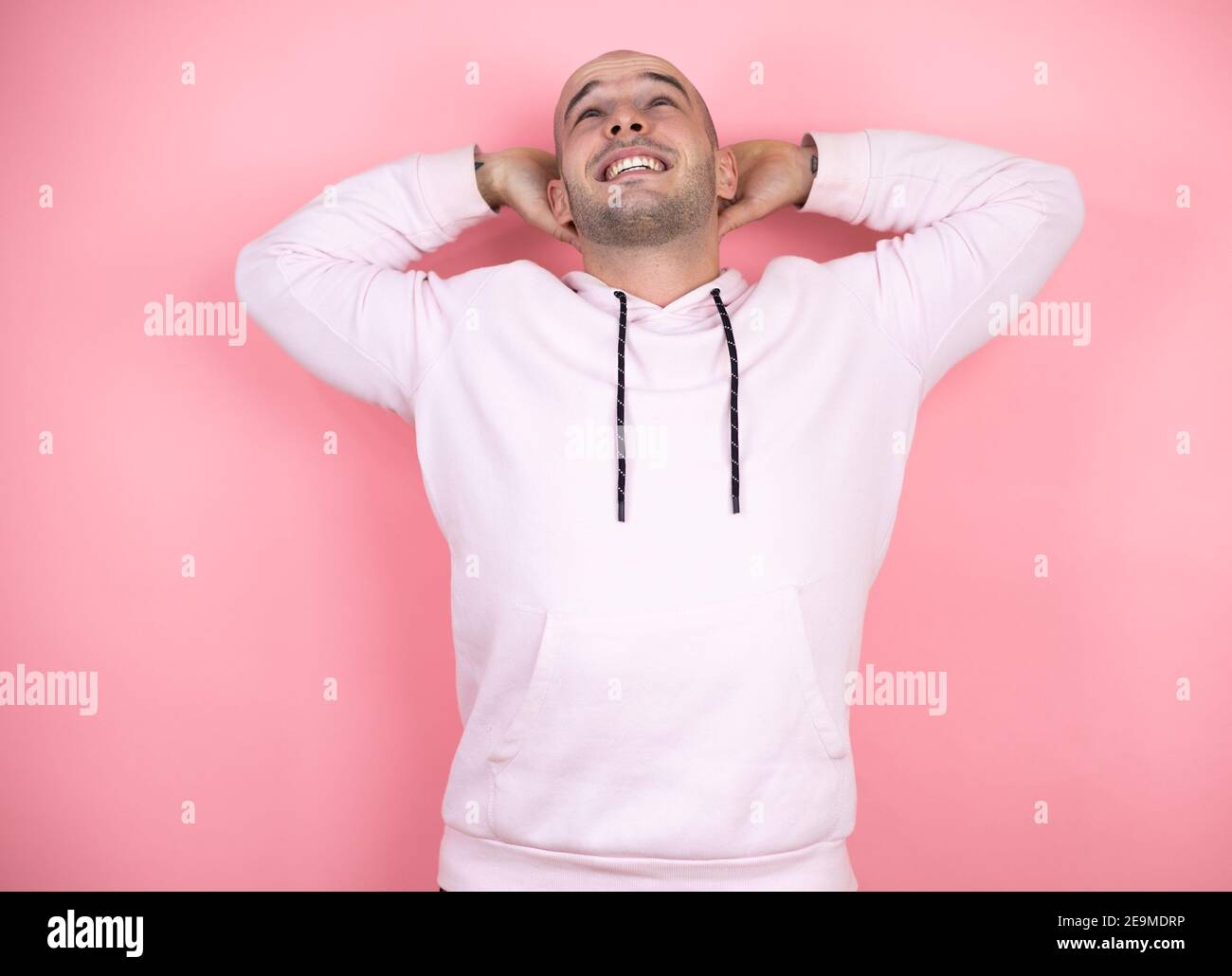Young bald man wearing casual sweatshirt over pink isolated background ...