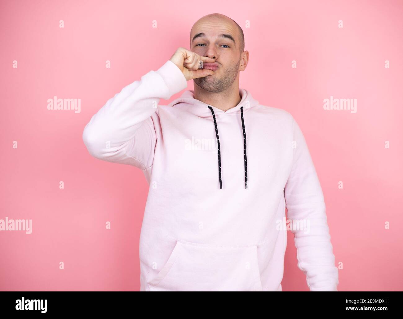 Young bald man wearing casual sweatshirt over pink isolated background ...