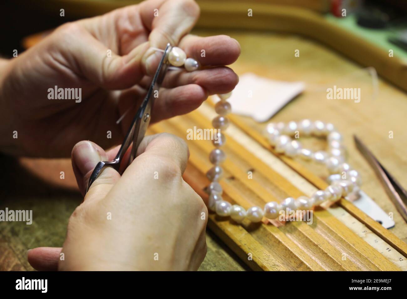 Pearl necklace knotting and threading at the jeweler Stock Photo - Alamy