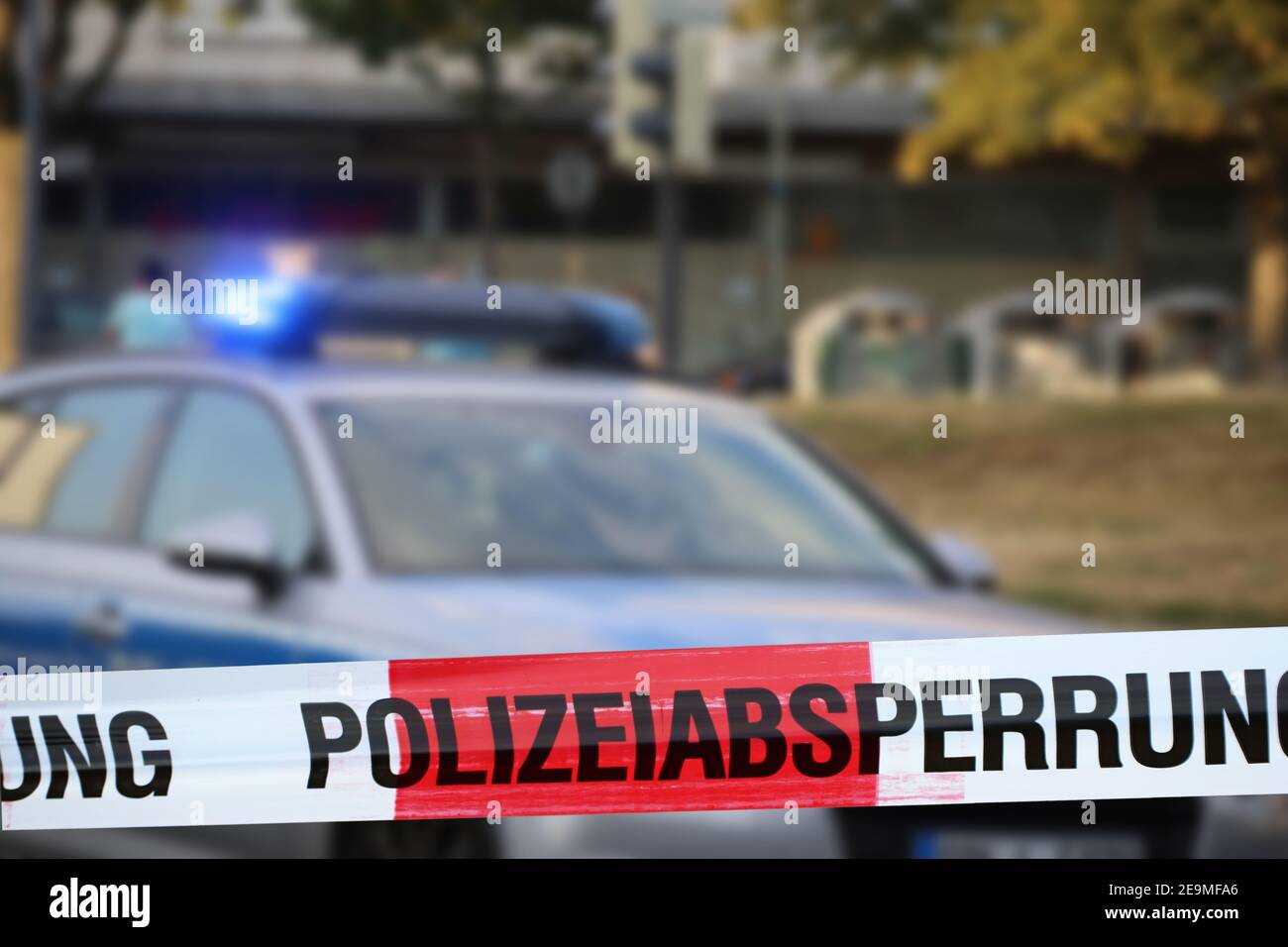 Symbol image: Police cordon tape with a police car in the background ...