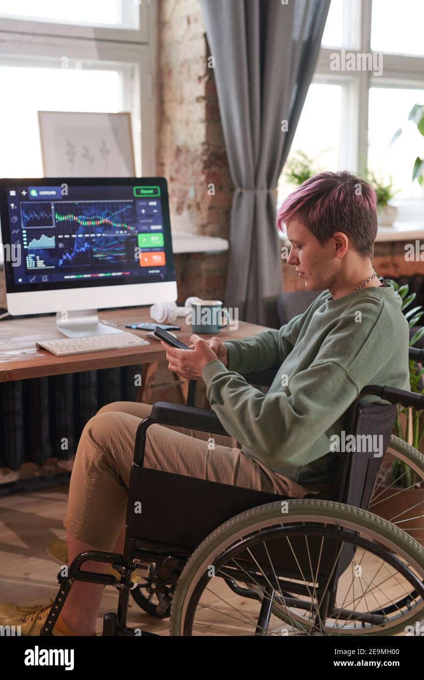 Disabled woman with short hair typing message on the phone during the ...