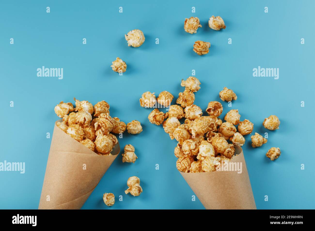 Caramel popcorn in a paper envelope on a blue background. Delicious ...