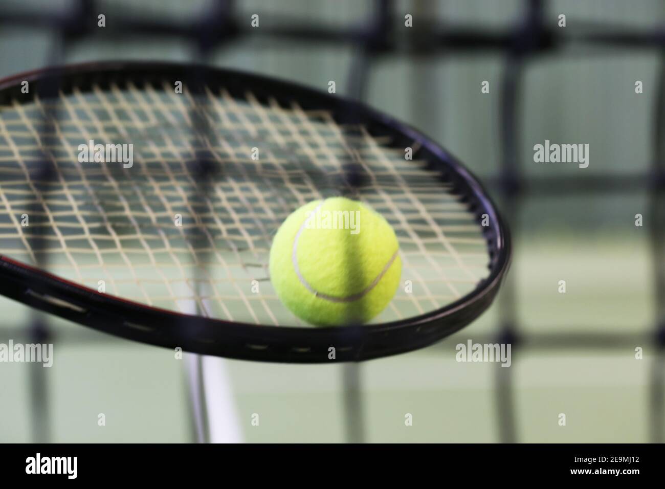 Symbol image: Close up of tennis racket with ball in tennis hall Stock ...