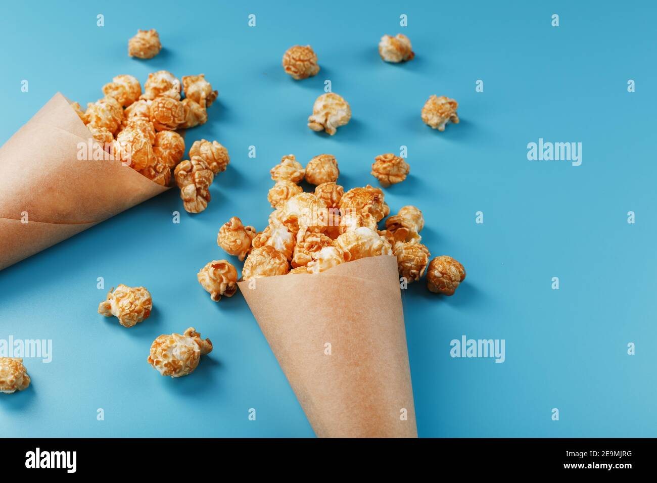 Caramel popcorn in a paper envelope on a blue background. Delicious ...