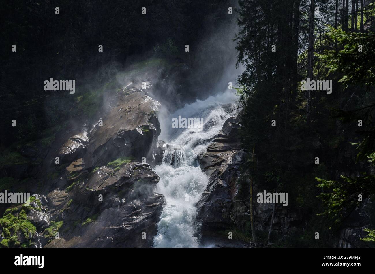 beautiful waterfall with sun in the dark forest Stock Photo - Alamy