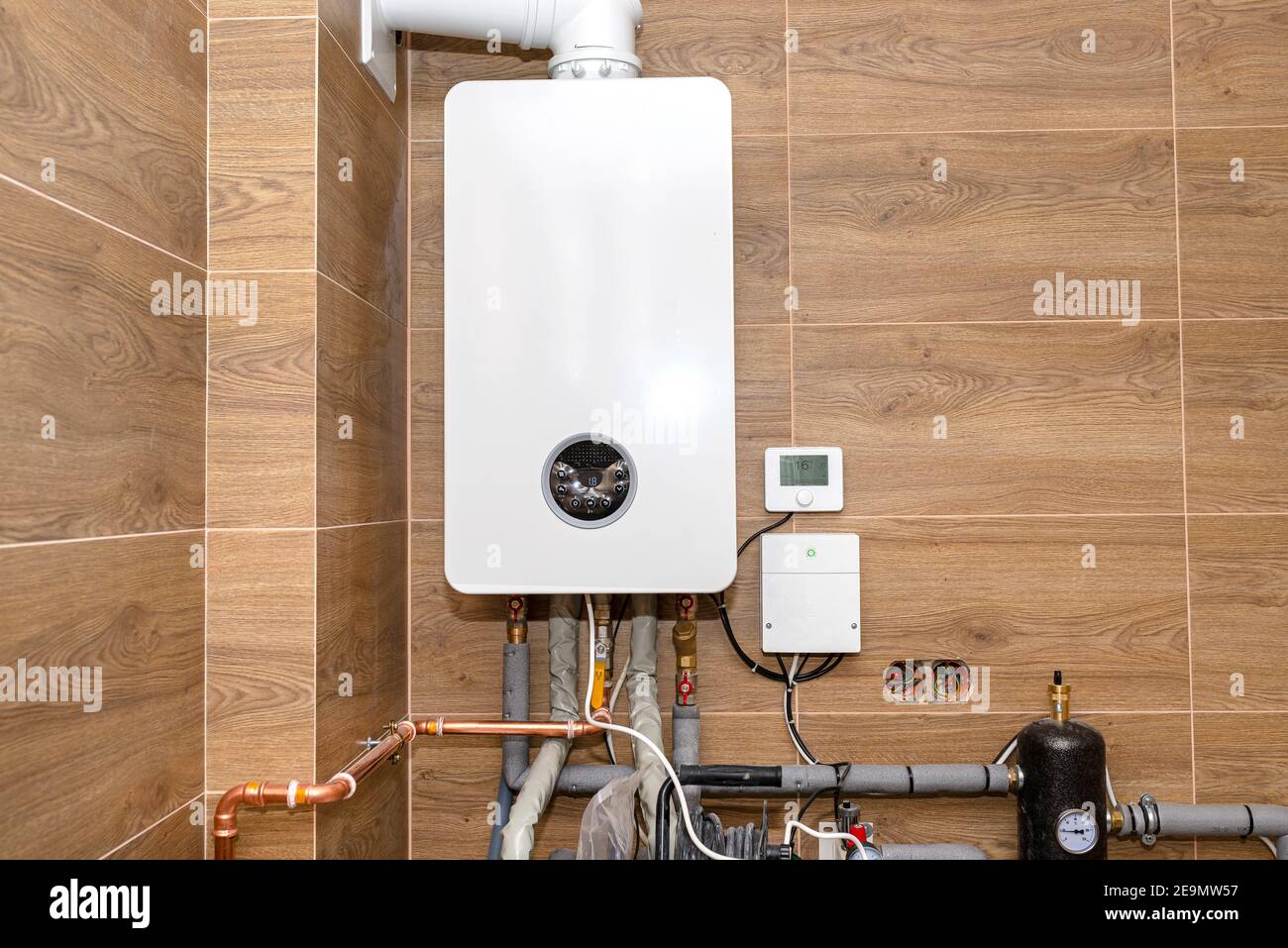 A modern gas boiler for natural gas, installed in a boiler room lined ...