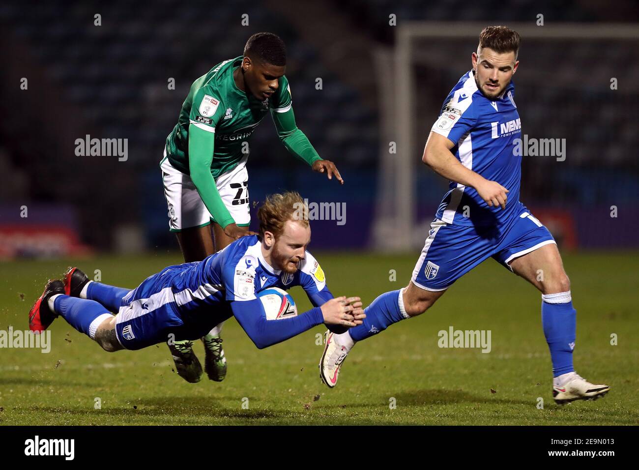 Gillingham’s Connor Ogilvie (bottom) goes down under the challenge of ...