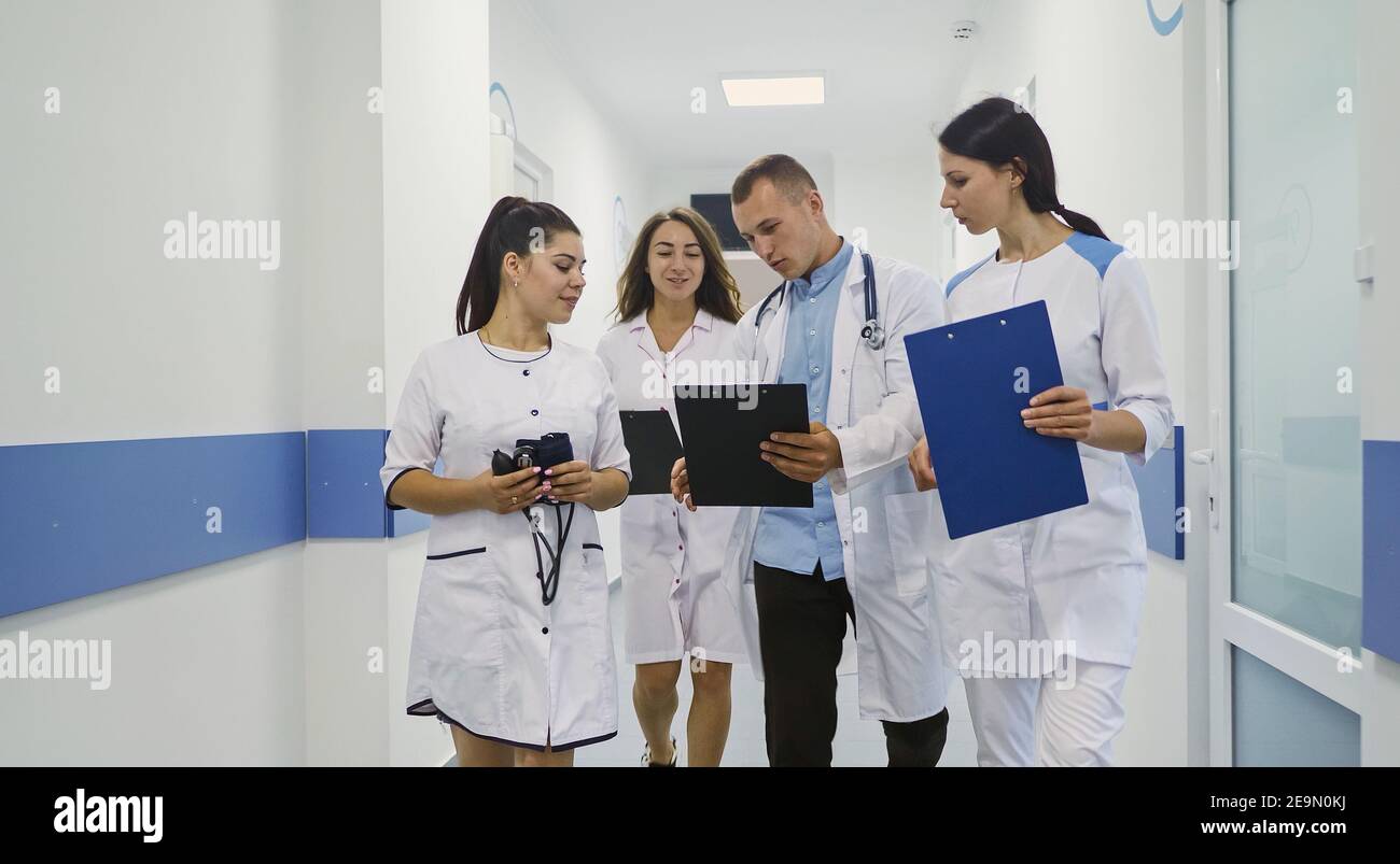 Team of Four Young Medical Interns Discussing the Diagnosis of a ...