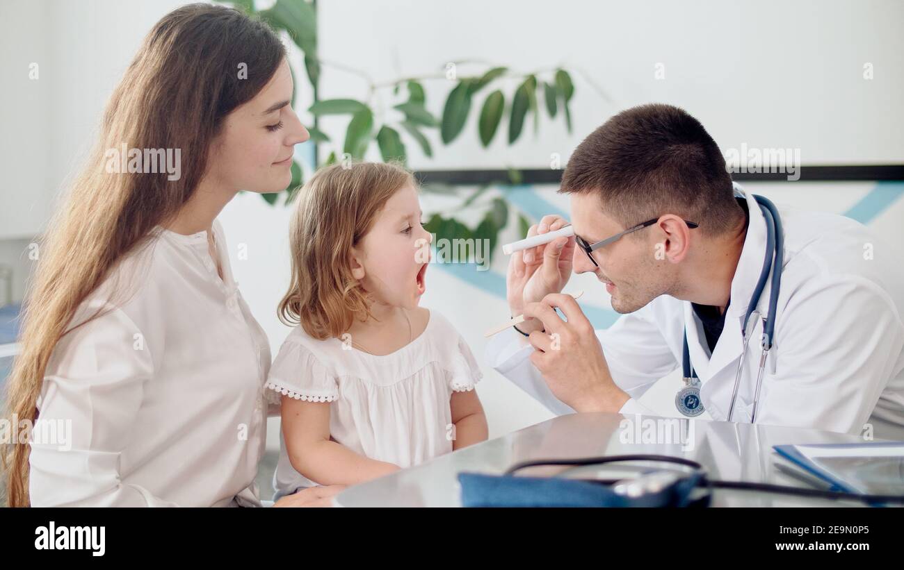 Male Doctor Pediatrician Examining an Ill Sad Kid Girl at Medical Visit ...