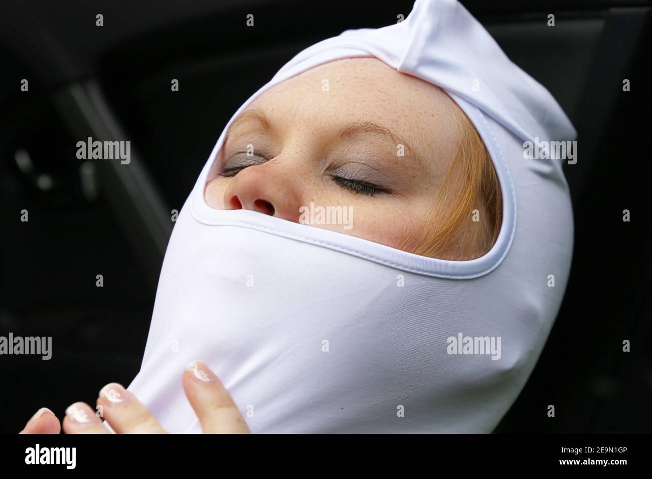 Symbol image: Female race car driver putting on her balaclava (Model ...