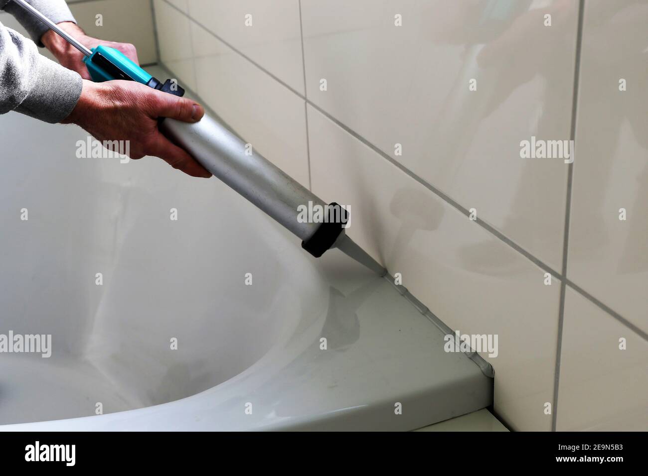 Grouting work. Tiler grouting in a new bathroom Stock Photo - Alamy
