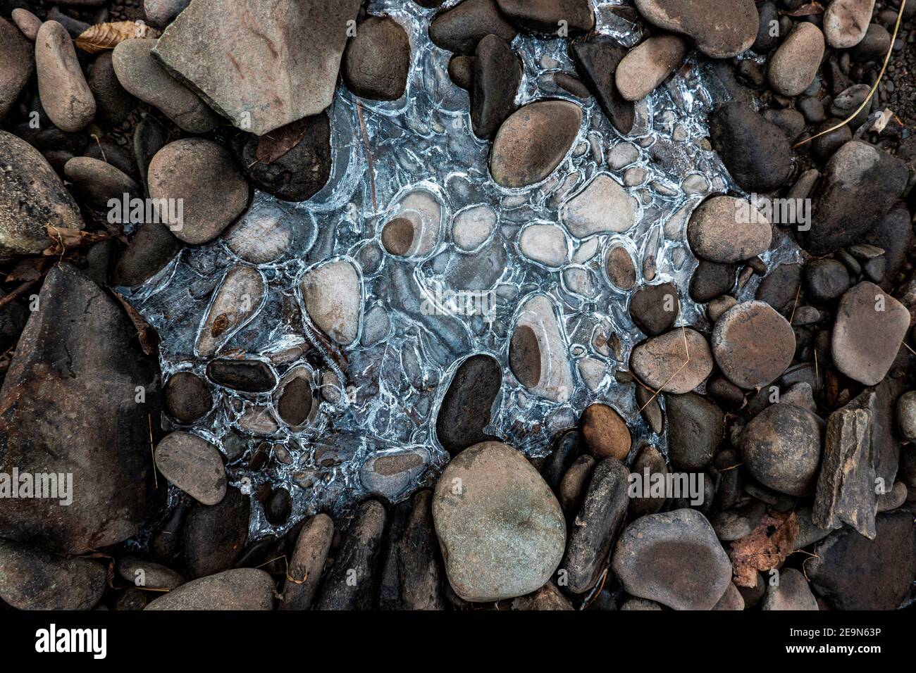 flat rounded stones with rocks and ice Stock Photo - Alamy