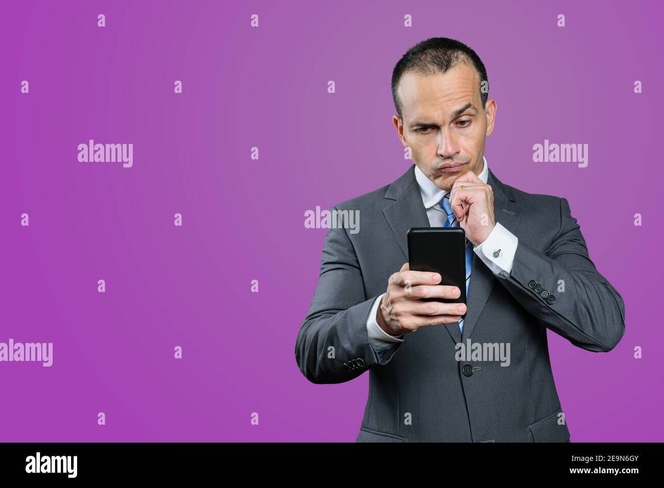Mature Brazilian man, in formal wear, with his smartphone in hand and ...