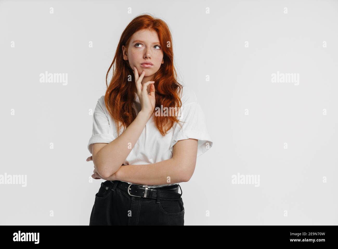 Ginger beautiful serious girl thinking and looking upward isolated over ...