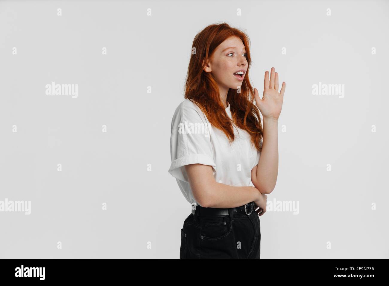 Ginger beautiful surprised girl posing and waving hand isolated over ...