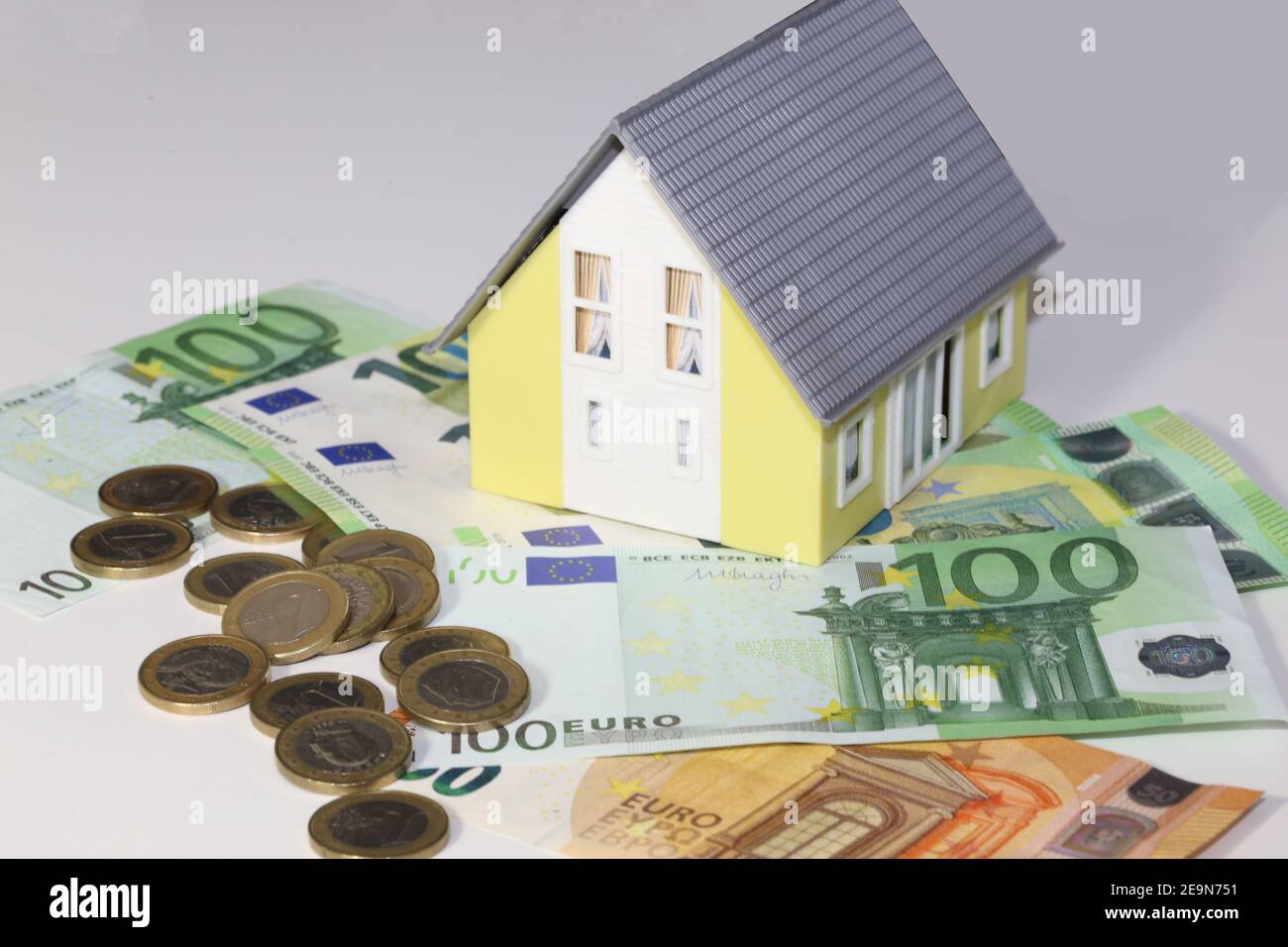 Symbol image: Model house with (euro)banknotes and coins as a symbol ...