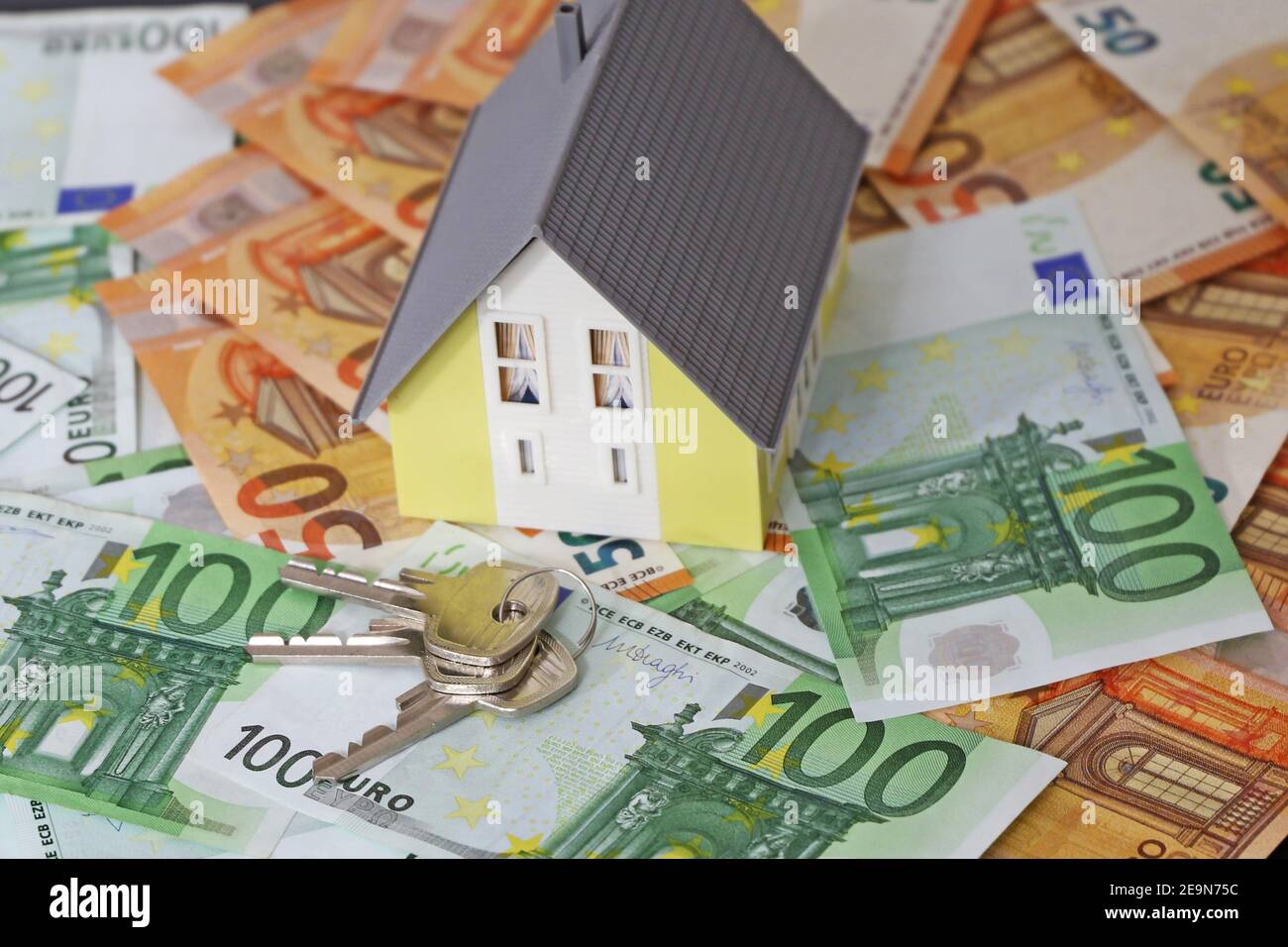 Symbol image: Model house with (euro)banknotes and coins as a symbol ...