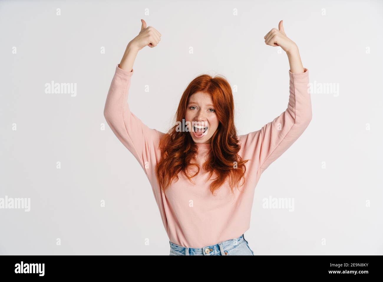 Ginger beautiful excited girl smiling and showing thumbs up isolated ...