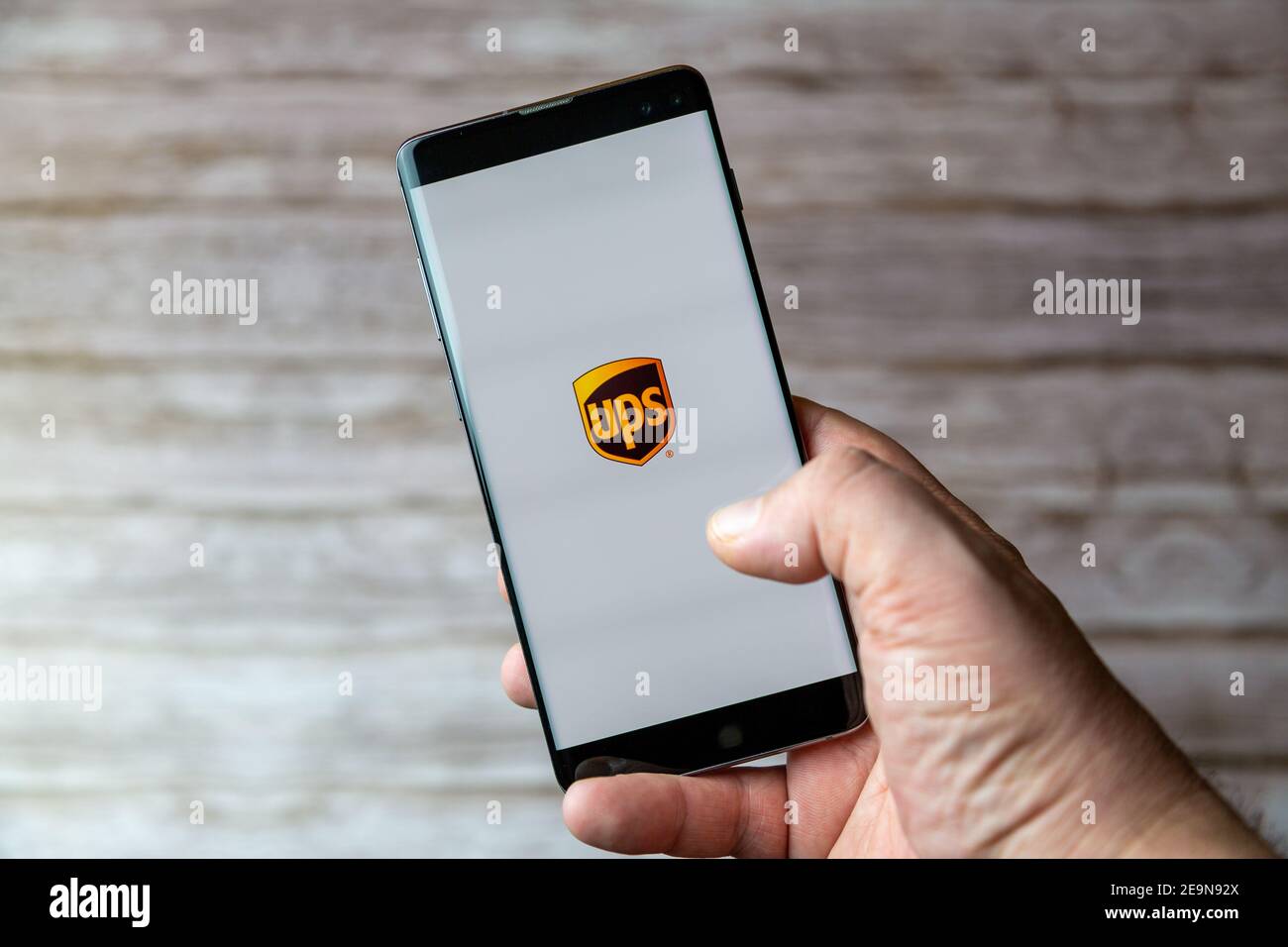 A Mobile phone or cell phone being held showing the UPS app open on ...