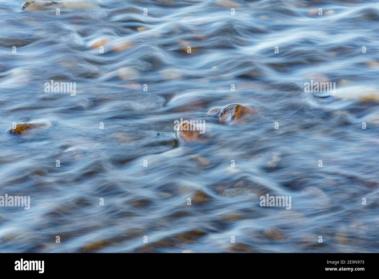 Closeup of Motion-Blurred Water Riffles Flowing over a Cobble Stone ...