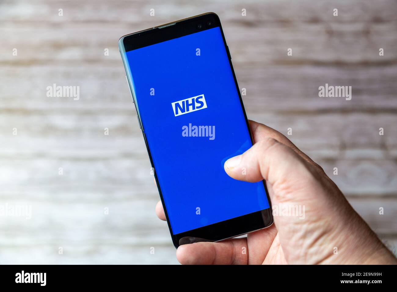 A Mobile phone or cell phone being held showing the NHS app open on ...