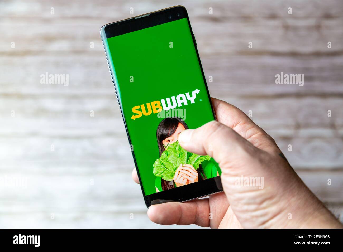 A Mobile phone or cell phone being held showing the Subway app open on ...