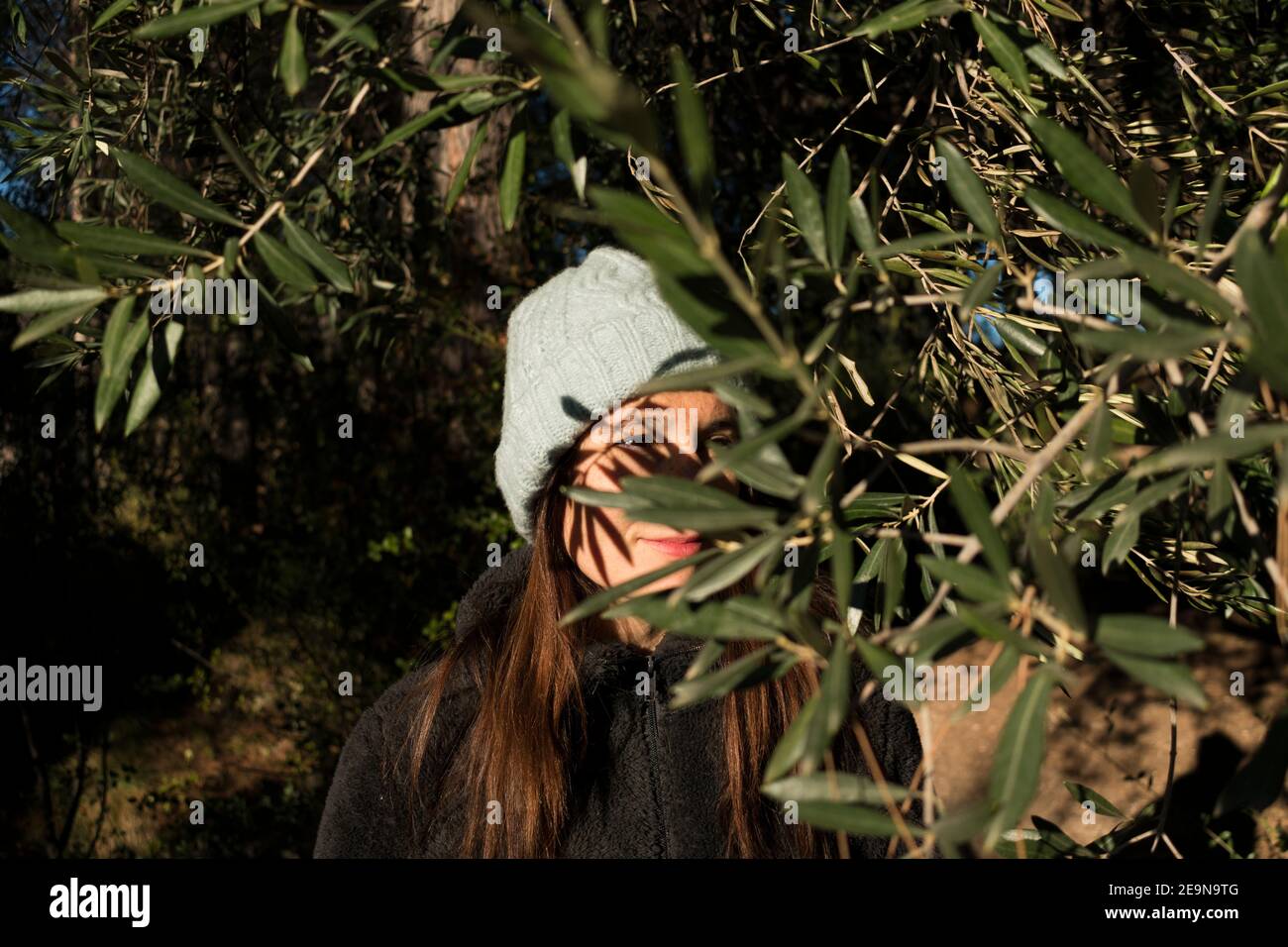 Young woman hiding behind bush hi-res stock photography and images - Alamy