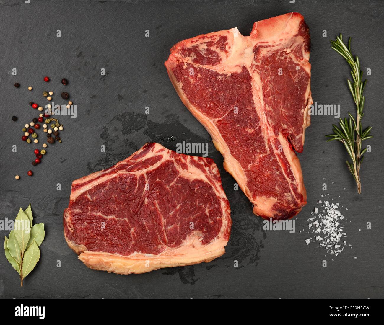 Close up marbled raw ribeye and porterhouse T bone beef steaks on black ...