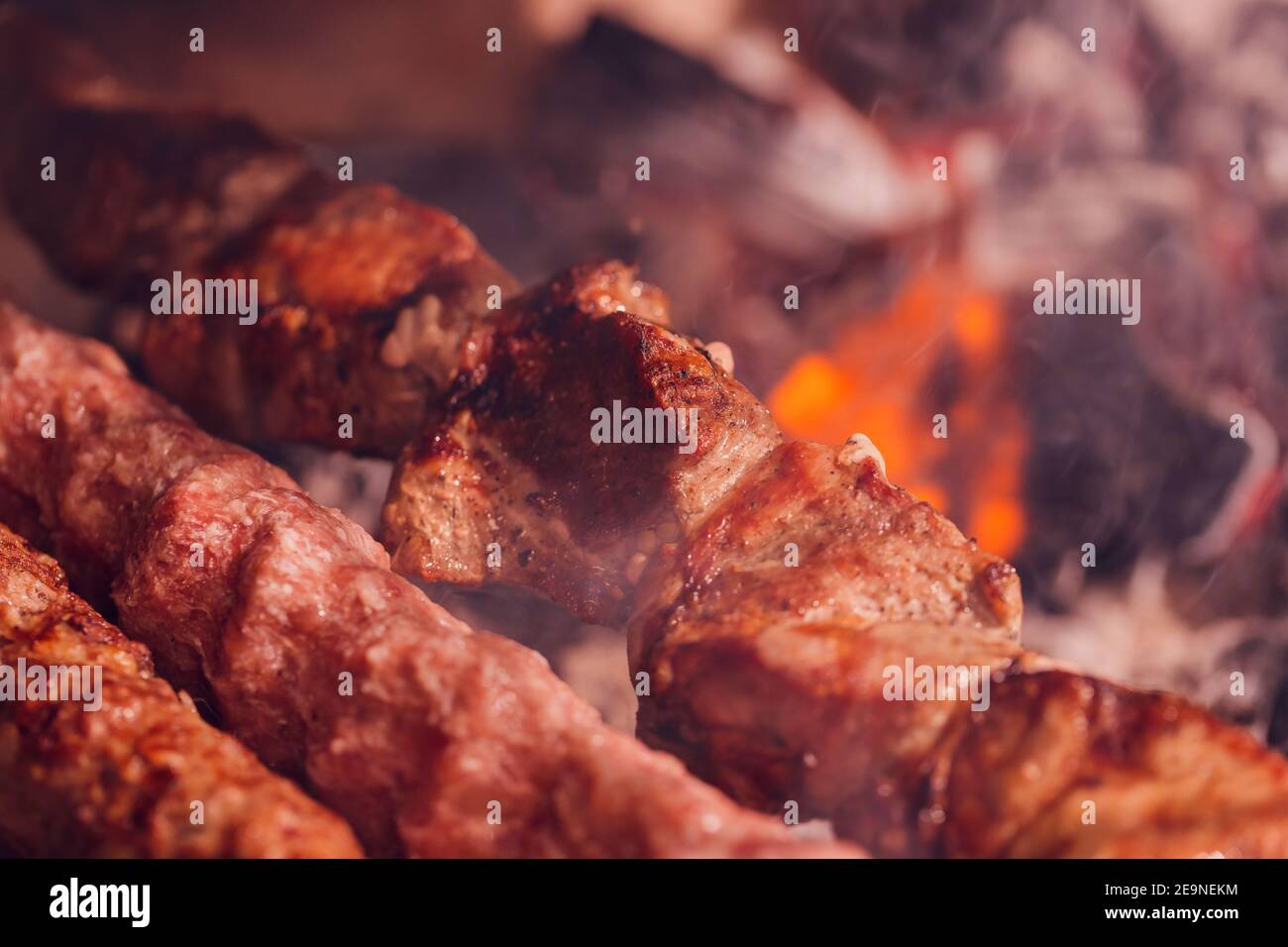 Grilled kebab cooking on metal skewer. Roasted meat cooked at barbecue ...