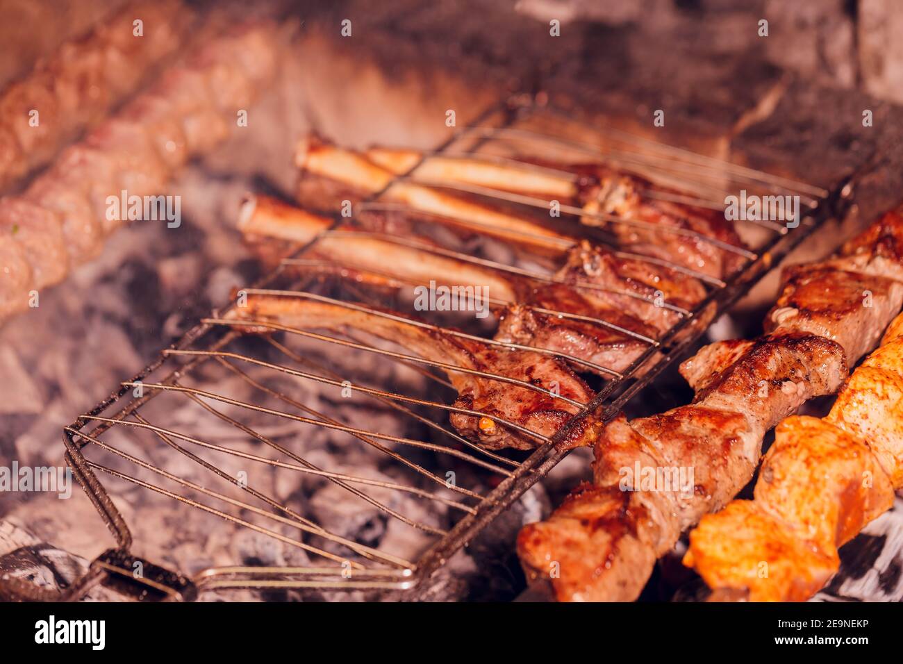 Grilled kebab cooking on metal skewer. Roasted meat cooked at barbecue ...