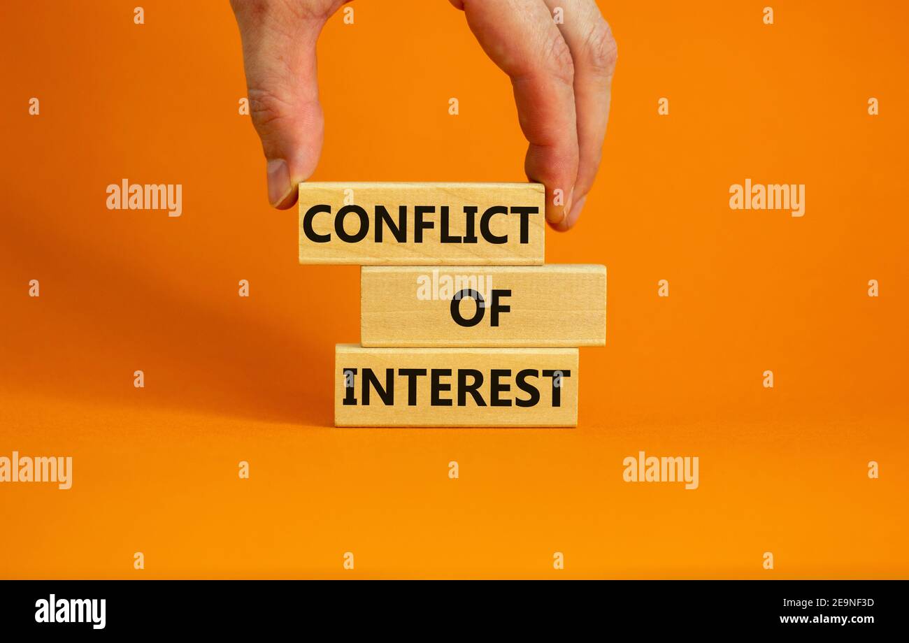 Conflict of interest symbol. Businessman hand. Wooden blocks with words ...