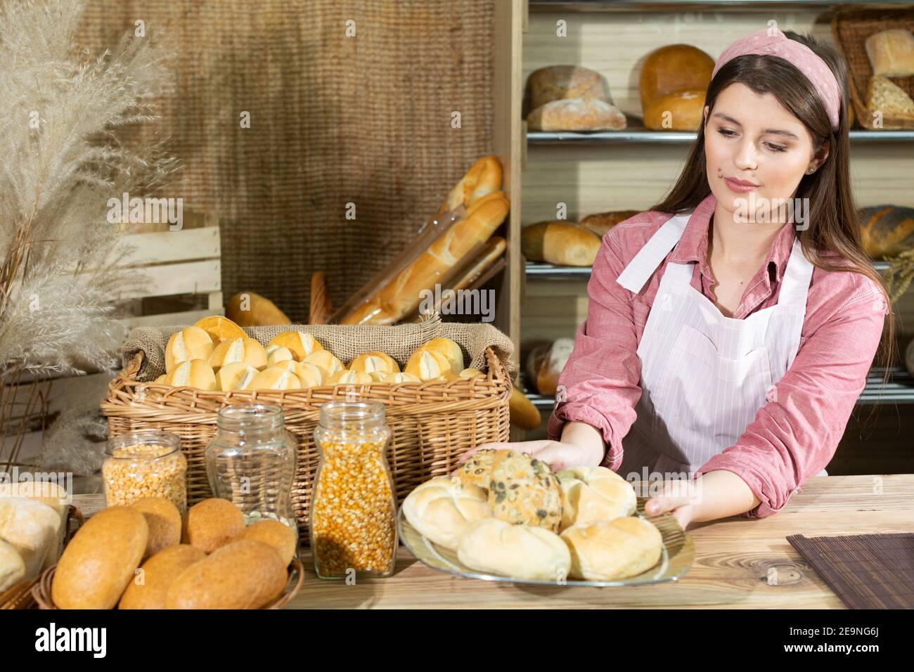 At the shop counter in a traditional bakery, the saleswoman arranges ...