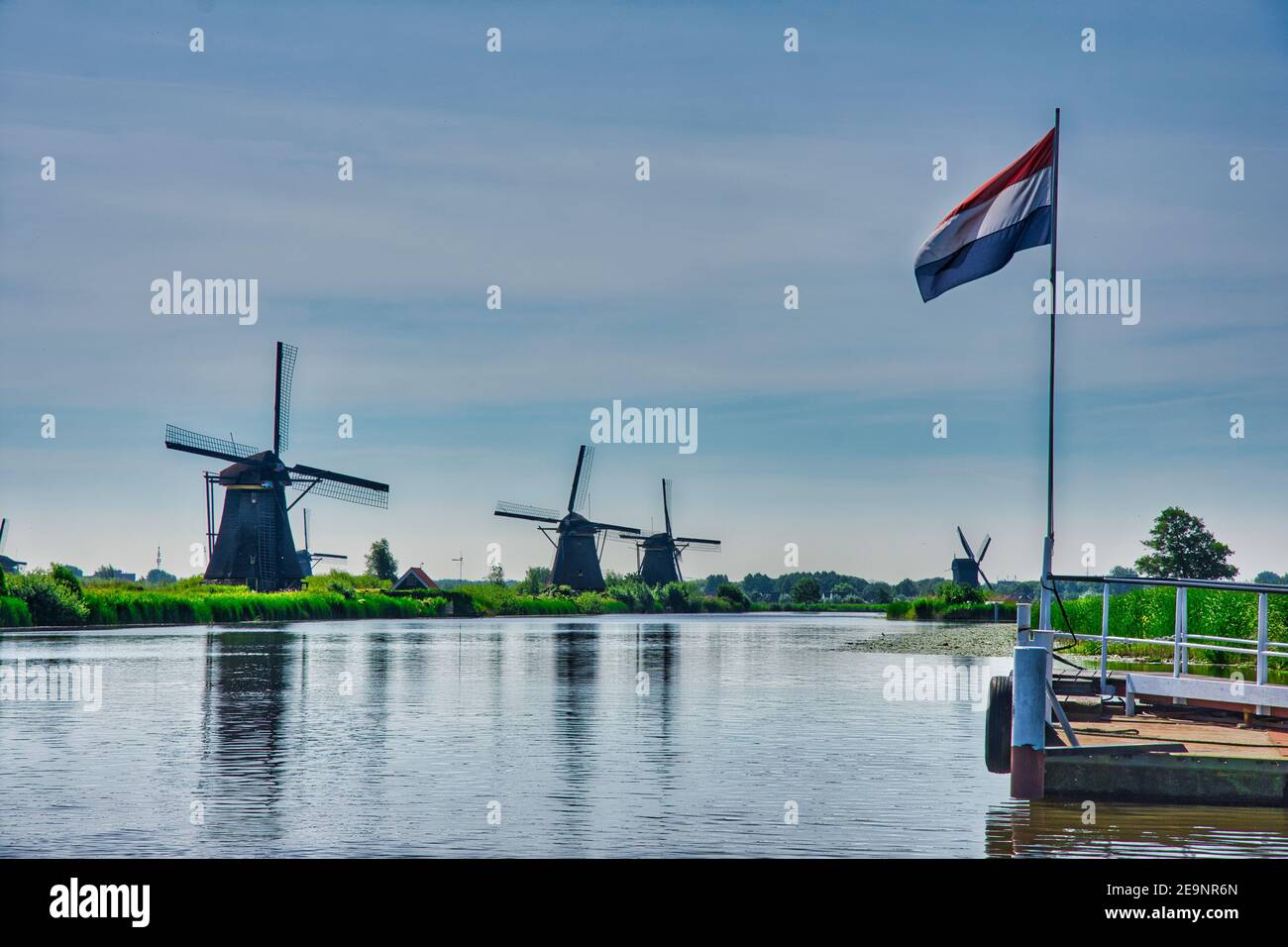 famous dutch windmills at riverside with Dutch flag Stock Photo - Alamy